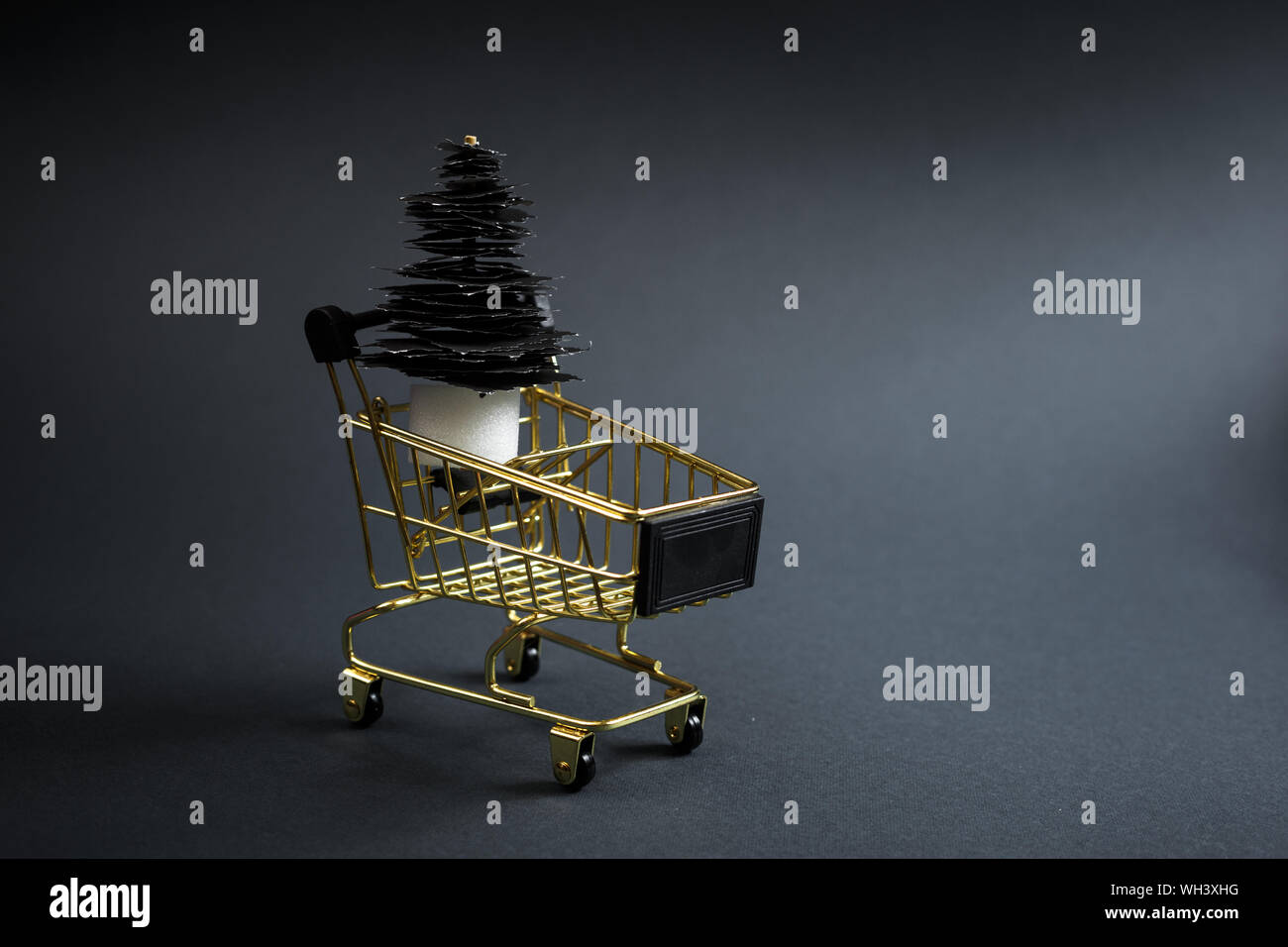 White Christmas tree in shop cart isolated on black background Stock ...