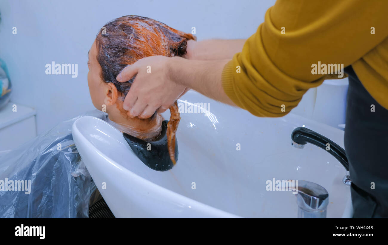 Hairdresser washing hair of woman client Stock Photo - Alamy