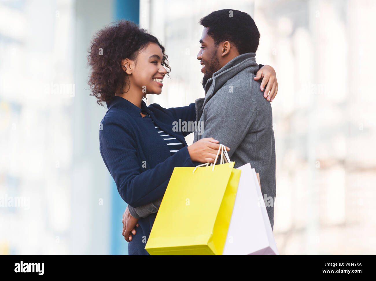 Black couple cuddling in the street after shopping Stock Photo - Alamy