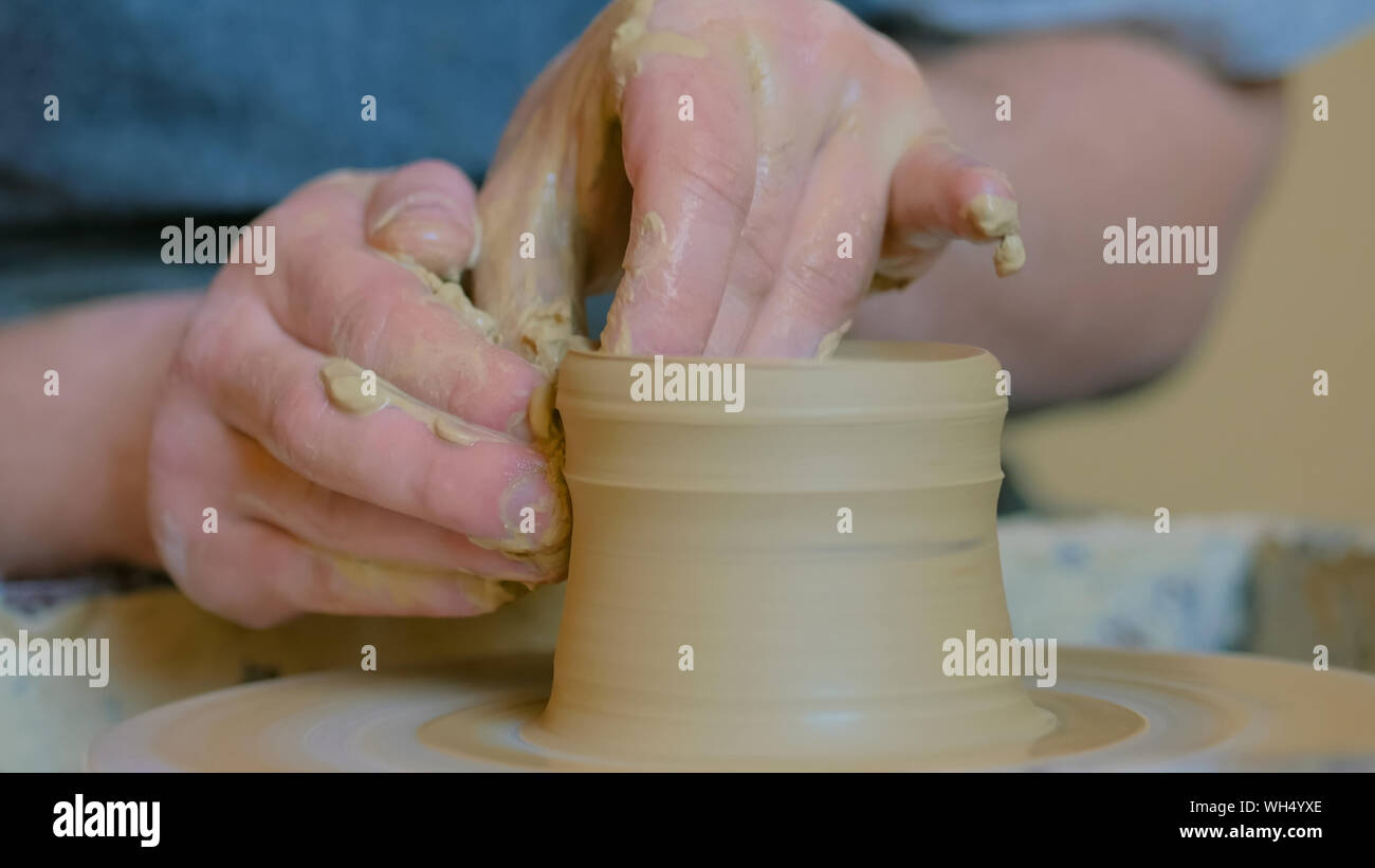 Professional potter shaping pot in pottery workshop Stock Photo - Alamy