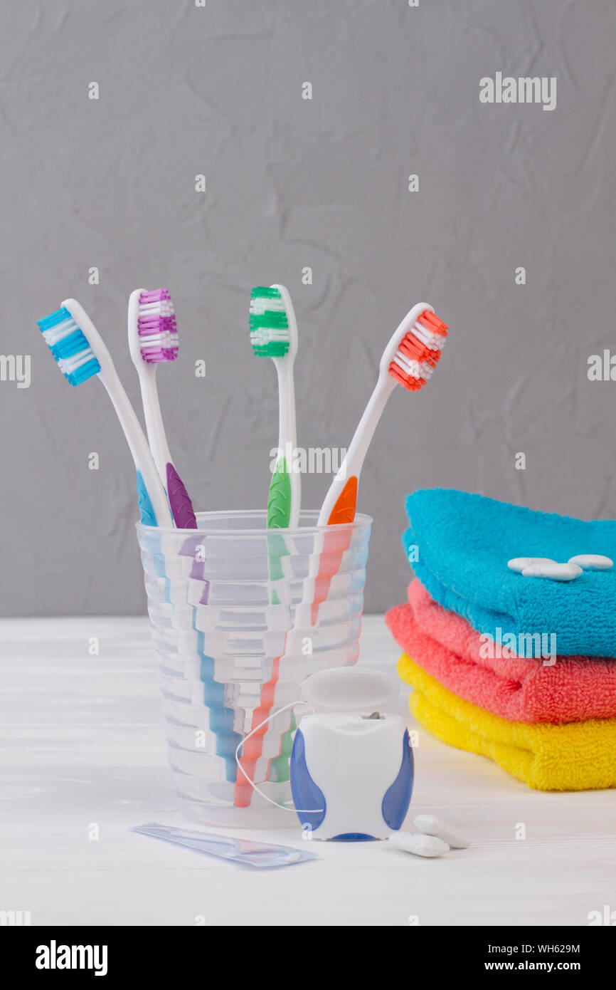 Toothbrush in glass, dental floss, towels and chewing gums Stock Photo ...