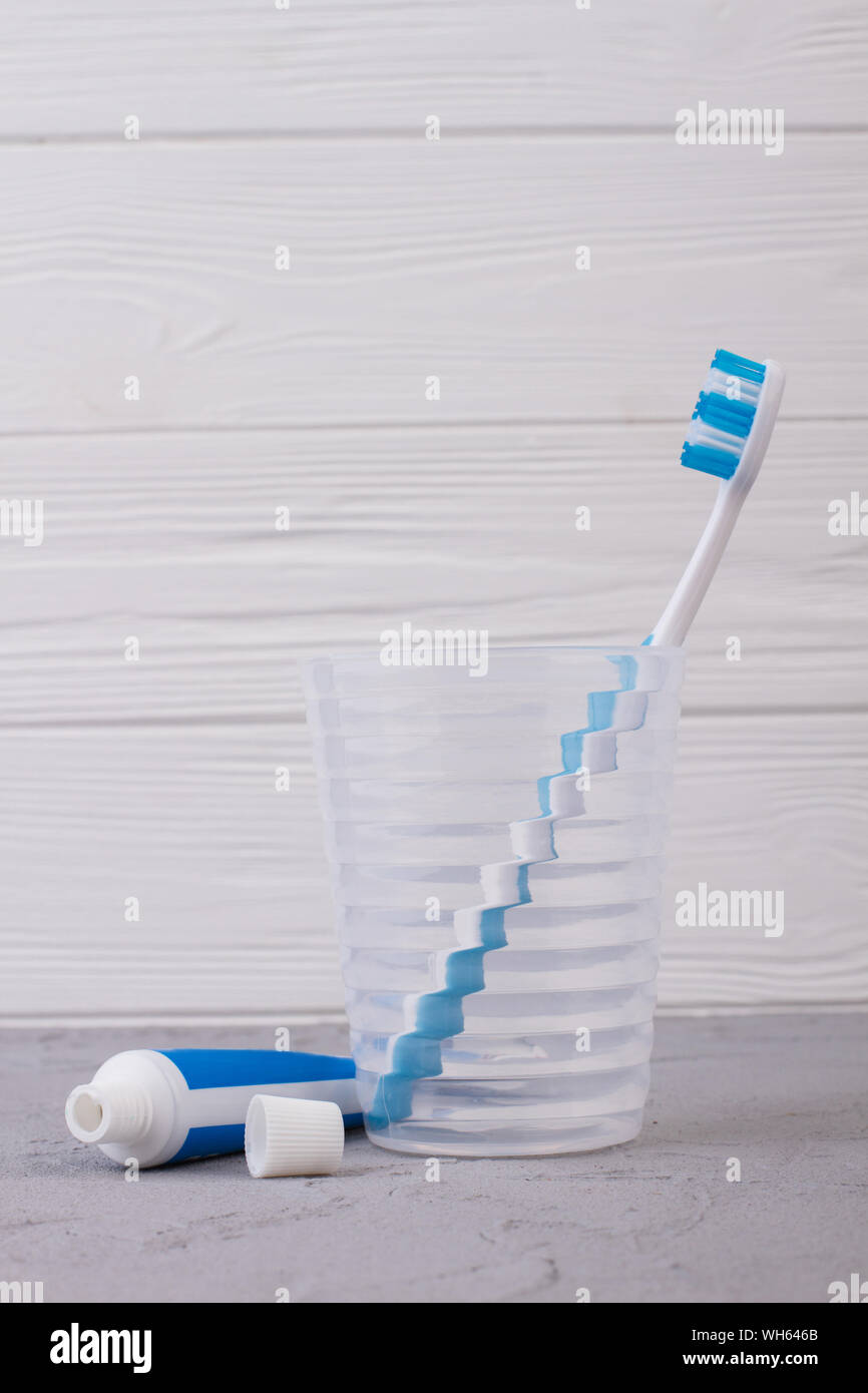 Tube of toothpaste and glass with toothbrush Stock Photo - Alamy
