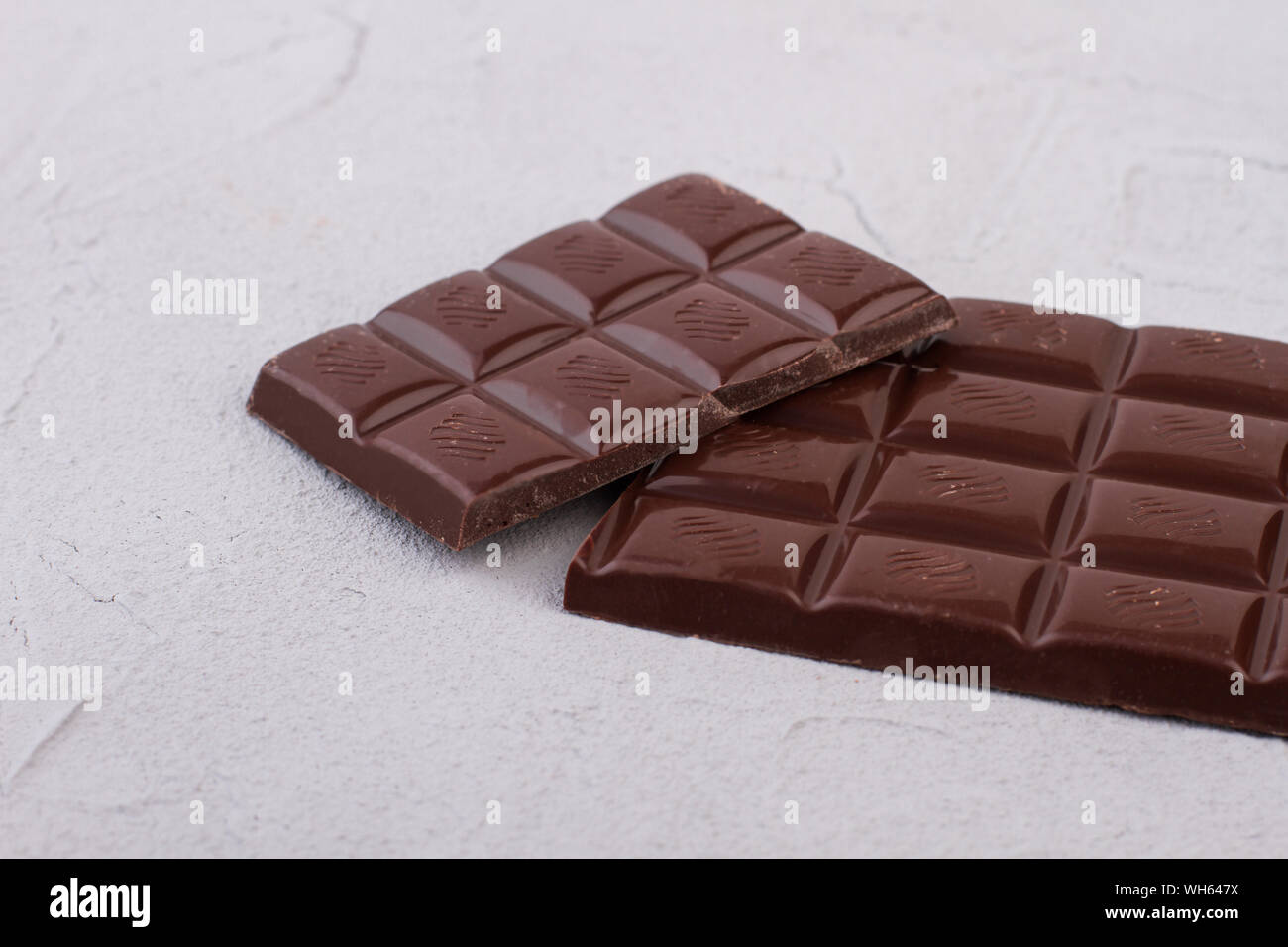 Chocolate bars on light background Stock Photo - Alamy