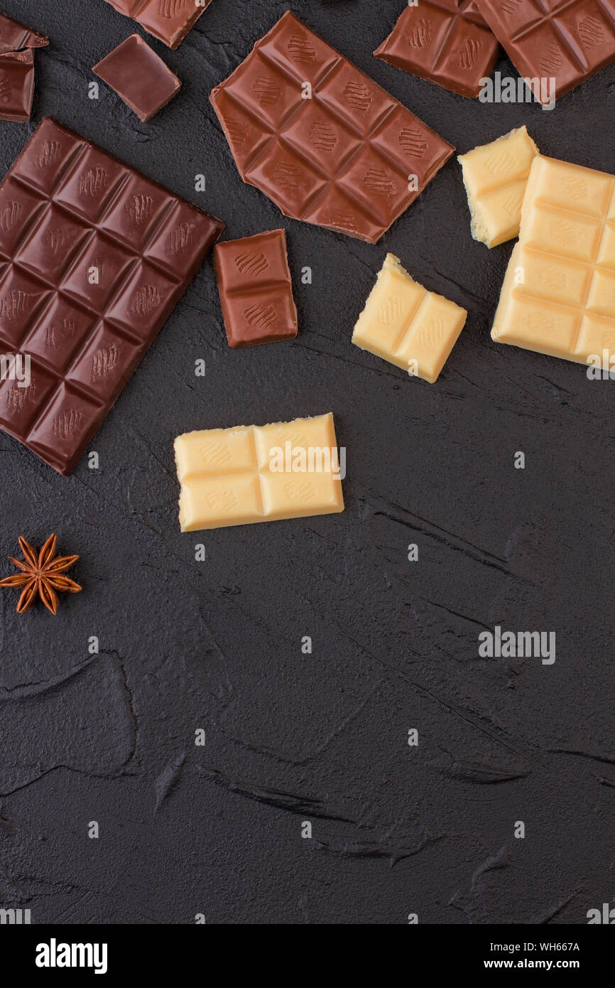 Different chocolate bars on black stone background Stock Photo - Alamy