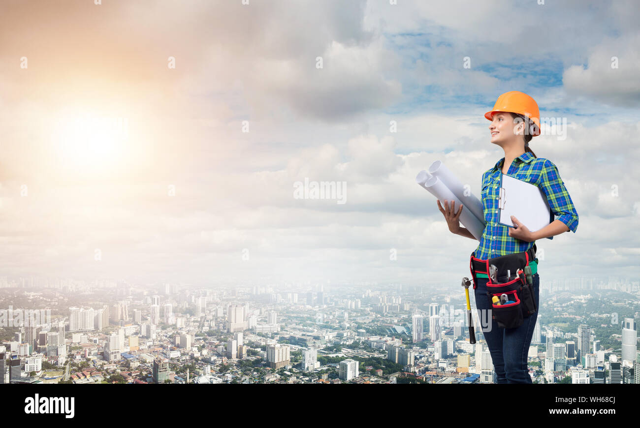 Engineer woman with blueprint on modern city landscape Stock Photo - Alamy