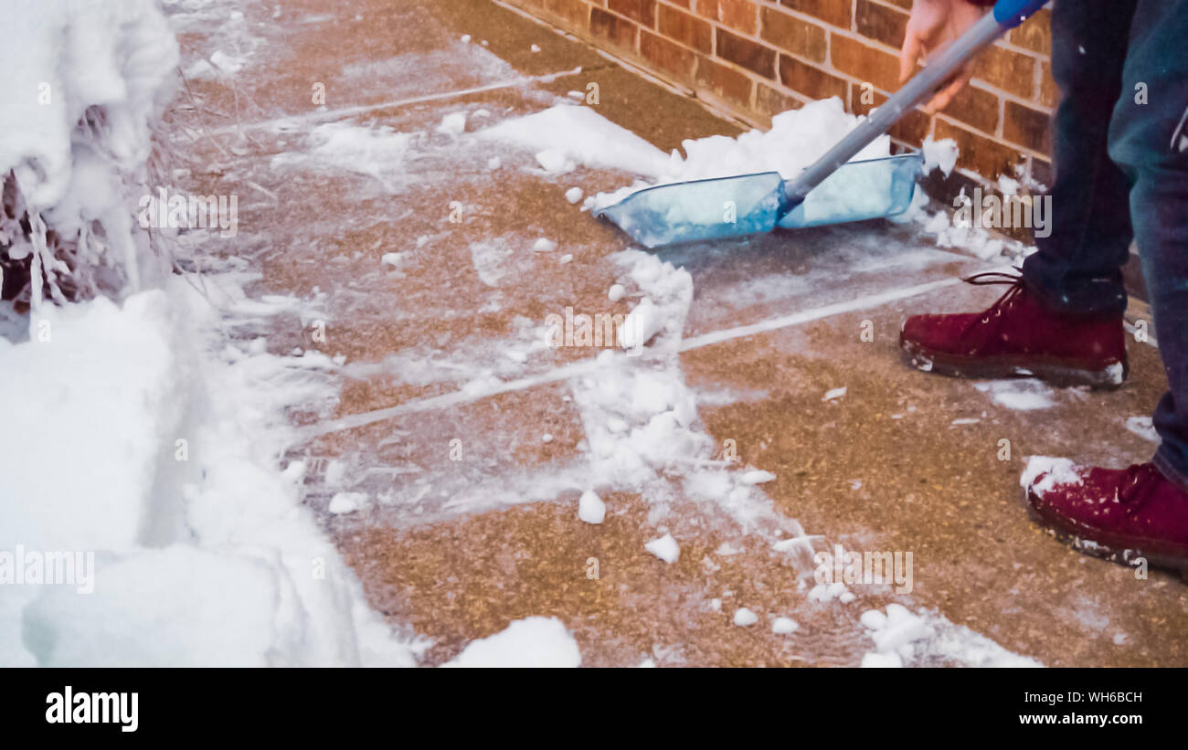 Young man shoveling snow from driveway Stock Photo - Alamy