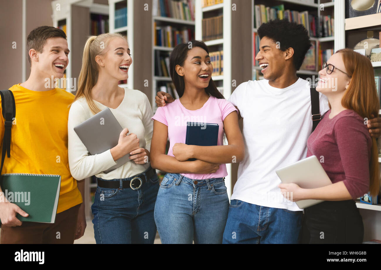 Team of students having fun in campus library Stock Photo - Alamy