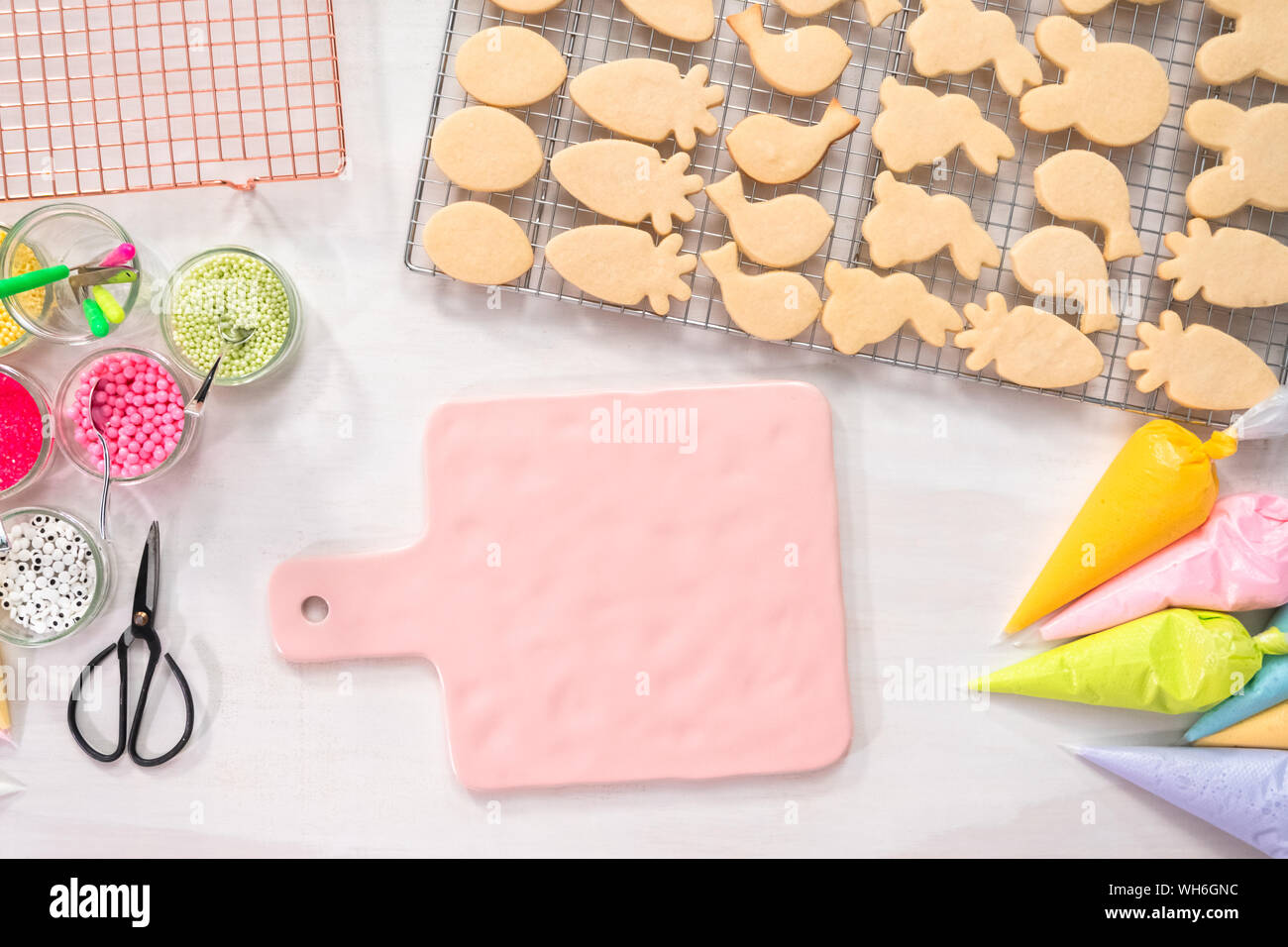 Flat lay. Decorating Easter sugar cookies with rotal icing Stock Photo ...