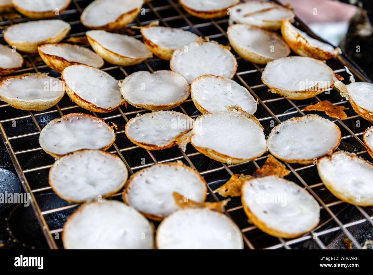 Khanom khrok or coconut-rice pancakes, Thai traditional dessert with coconut milk made on a ...