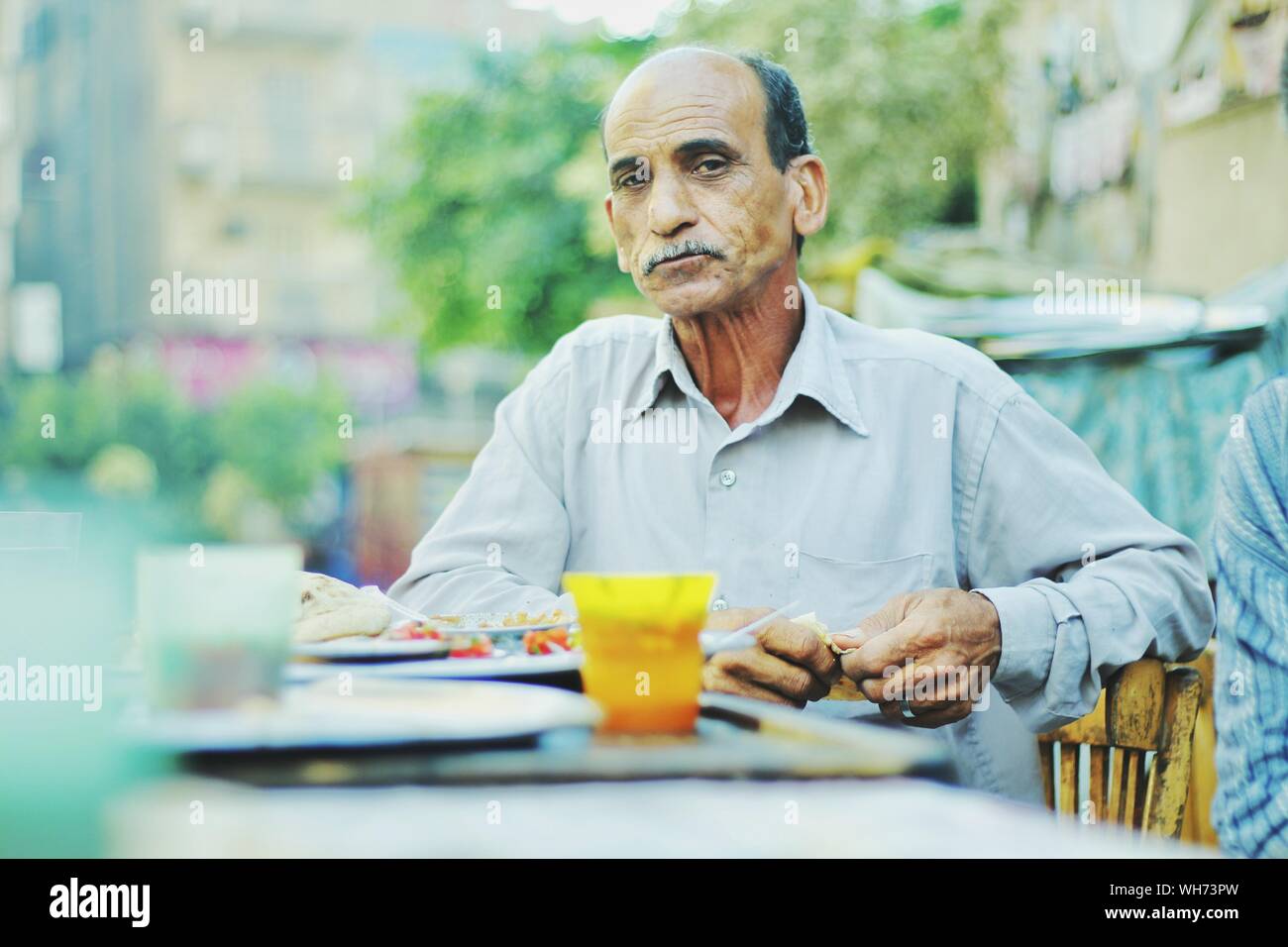 Men sitting table street hi-res stock photography and images - Alamy
