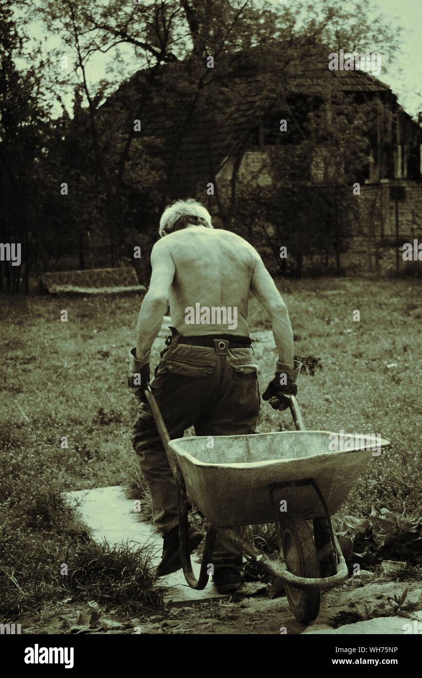 Man and his wheelbarrow hi-res stock photography and images - Alamy
