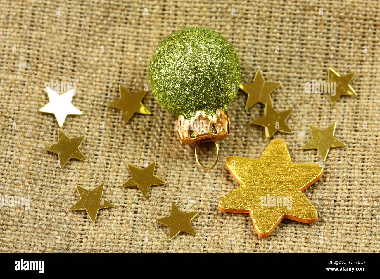 Christmas green bauble and gold stars on flax texture Stock Photo - Alamy