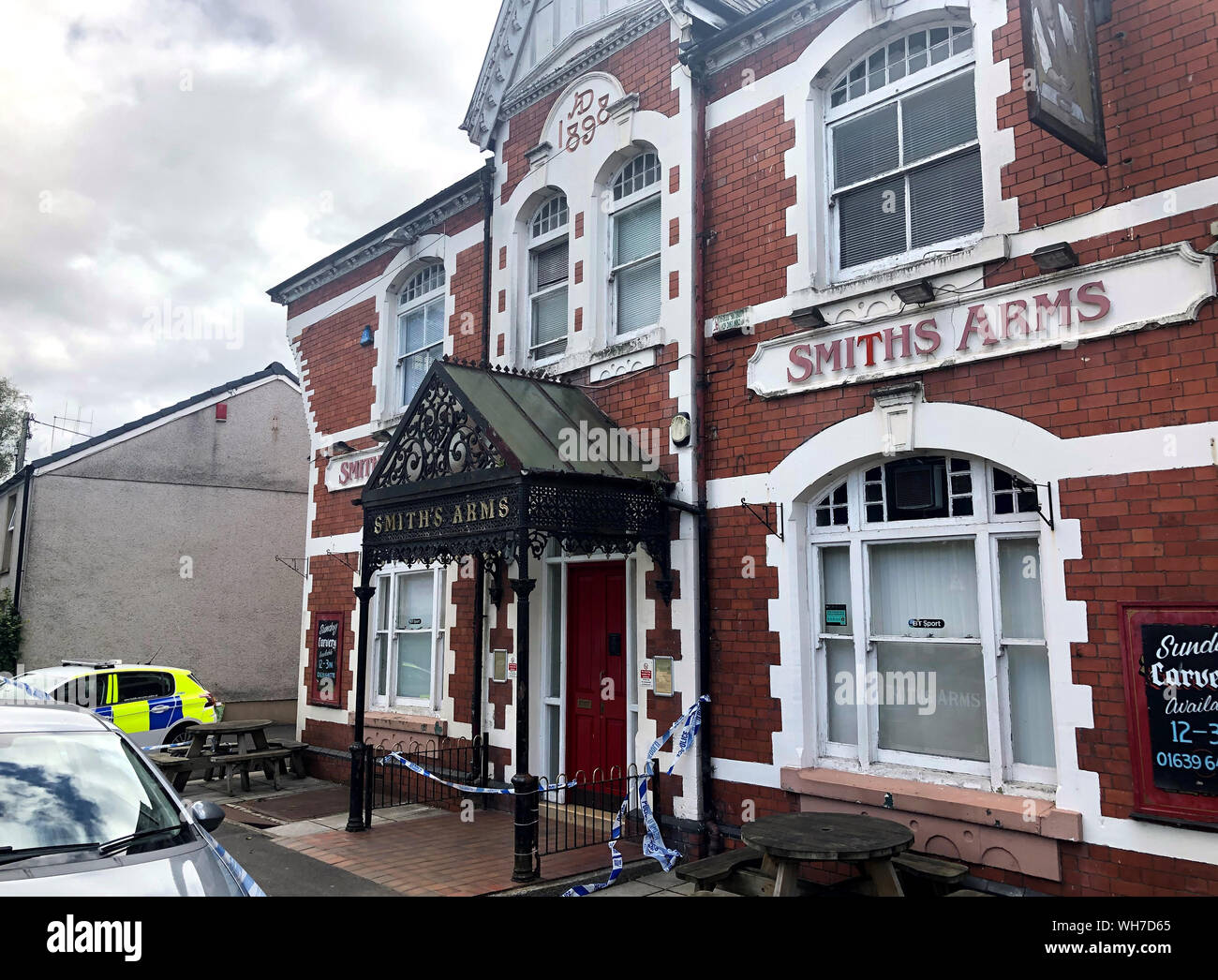 Police tape and vehicles outside the Smiths Arms public house in Neath ...