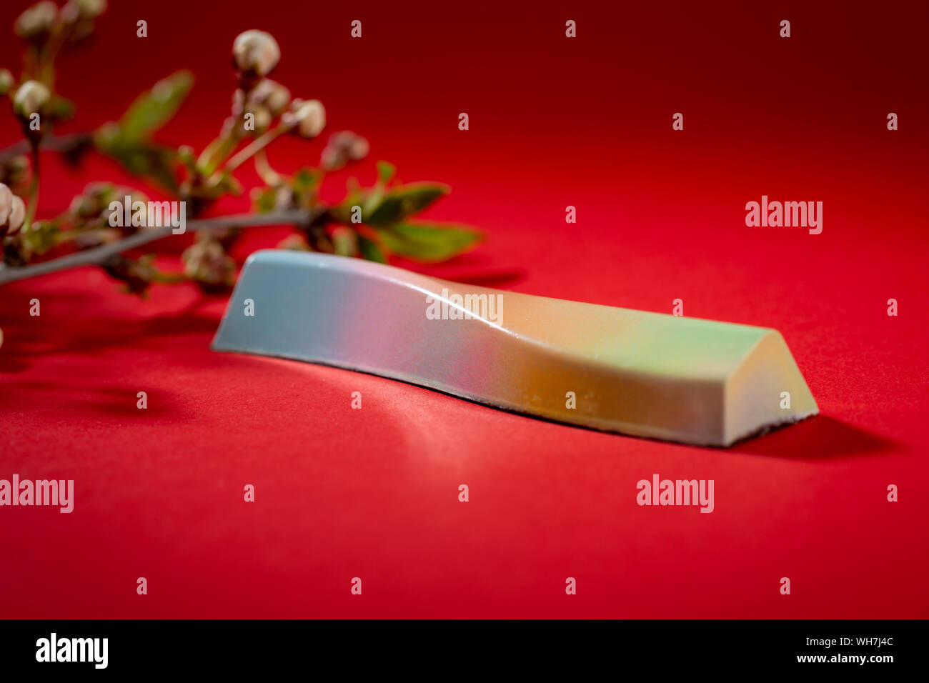 One chocolate color bar candy on red Stock Photo - Alamy