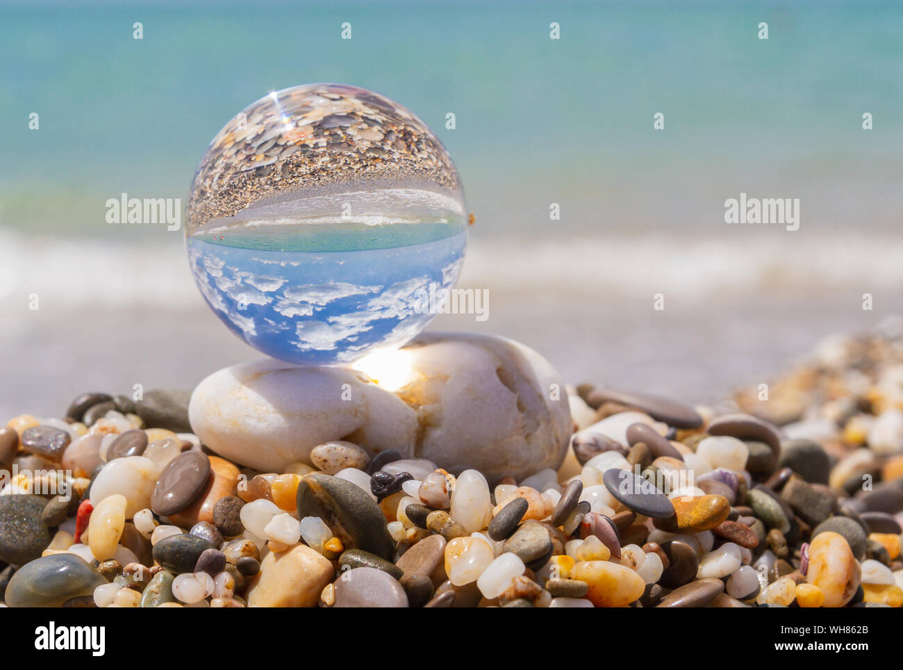 Glass round ball on the beach reflects the sea in summer Stock Photo ...