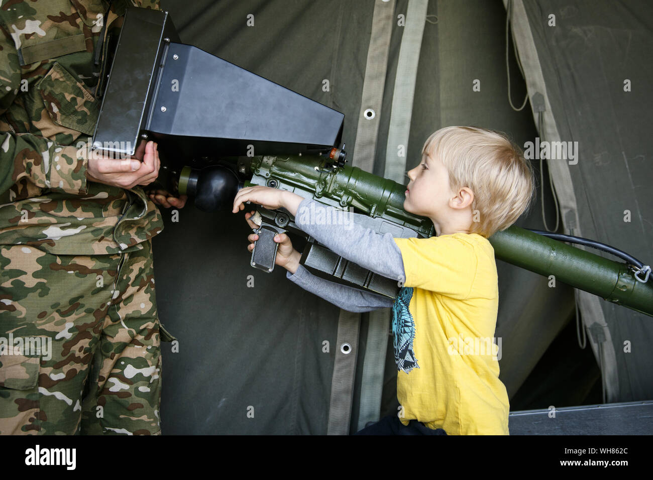 Soldier introducing anti-aircraft air defence simulator to a boy child ...