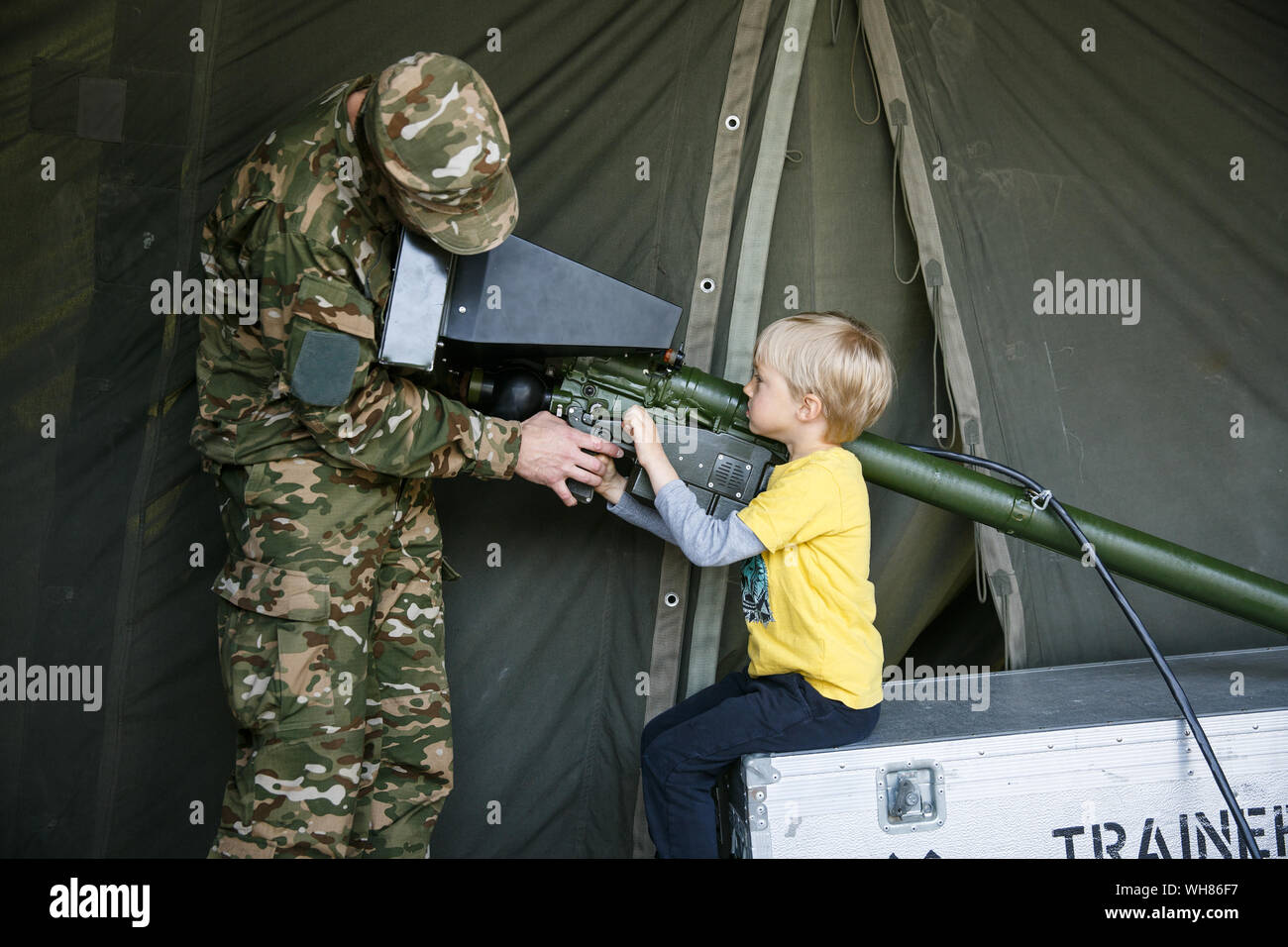 Soldier introducing anti-aircraft air defence simulator to a boy child ...