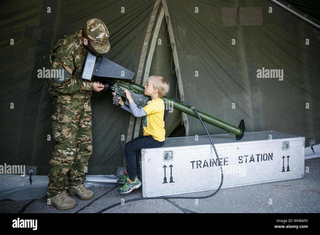Soldier introducing anti-aircraft air defence simulator to a boy child ...