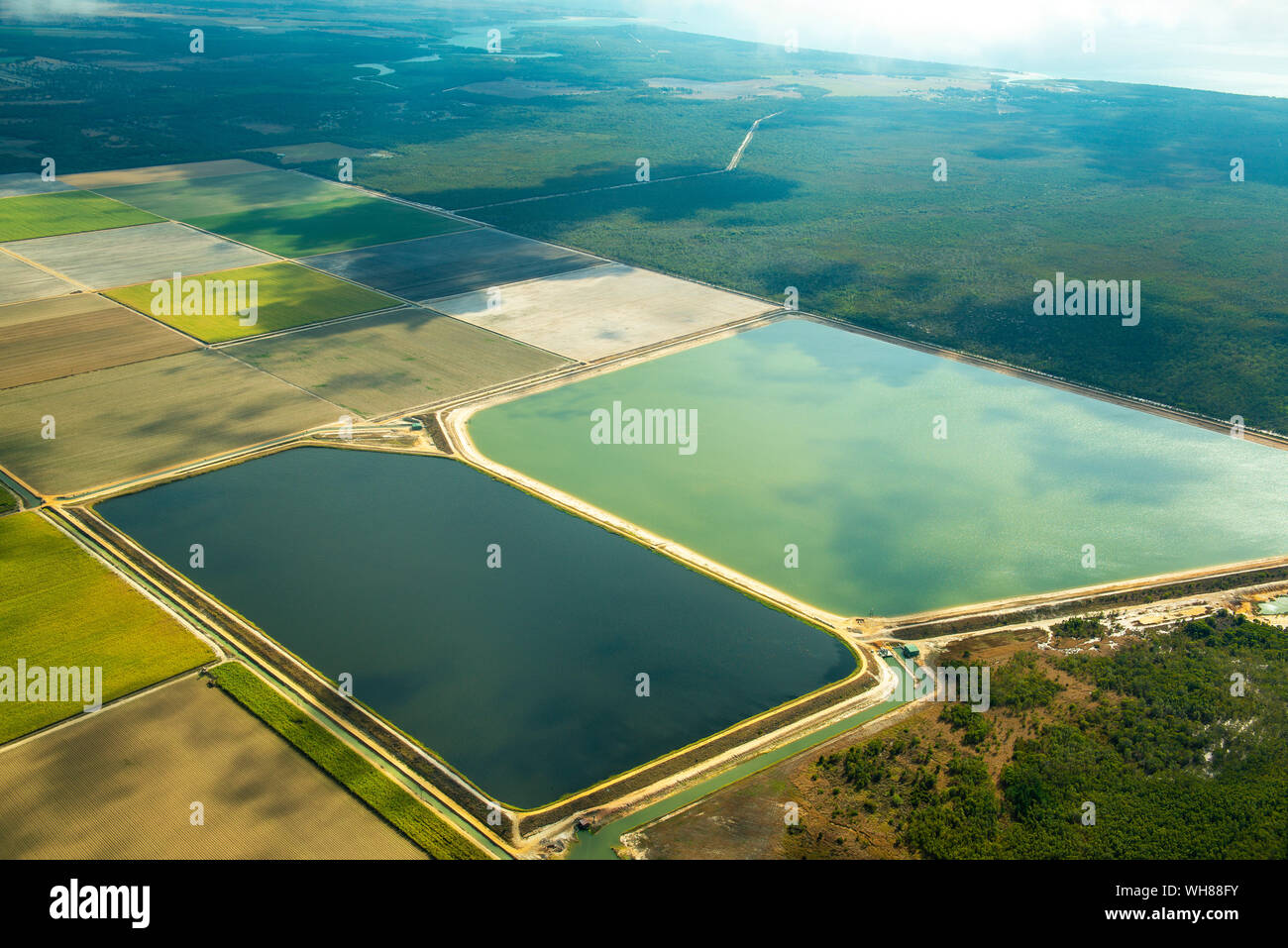 Aerial view of green fields cultivated and two large ponds for watering ...