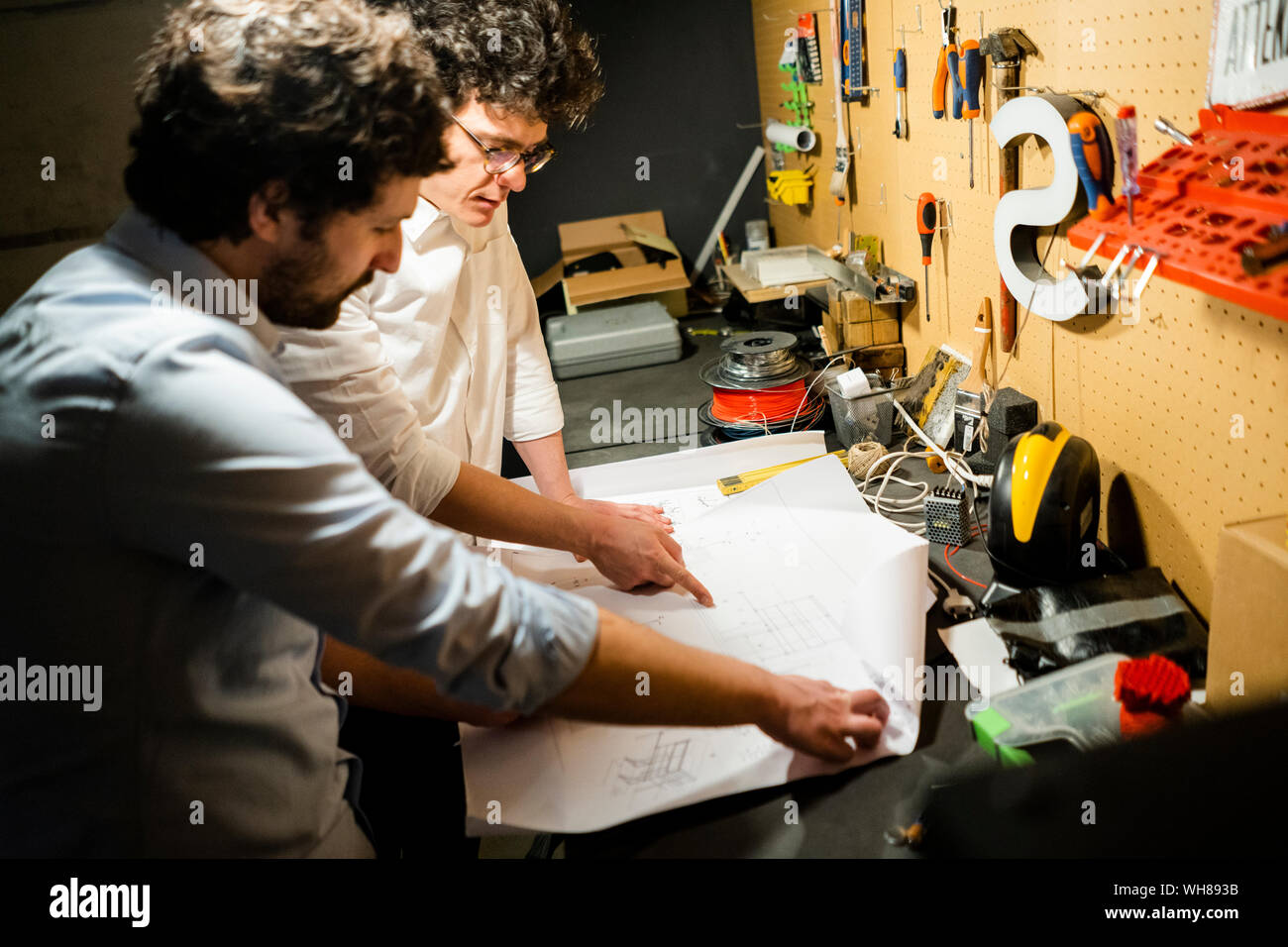 Two colleagues working on a construction plan together Stock Photo - Alamy