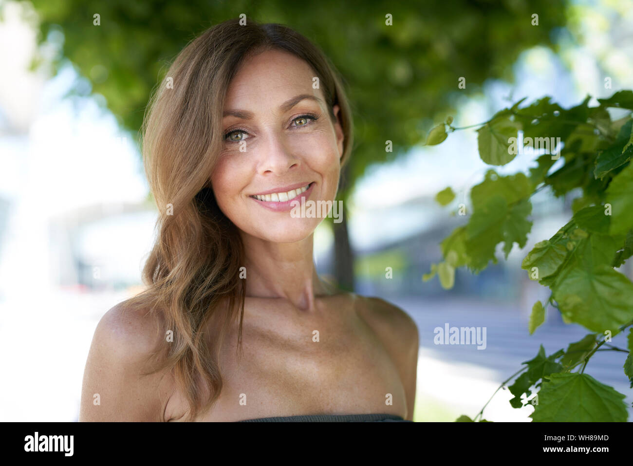 Portrait of mature woman, tree in the background Stock Photo - Alamy
