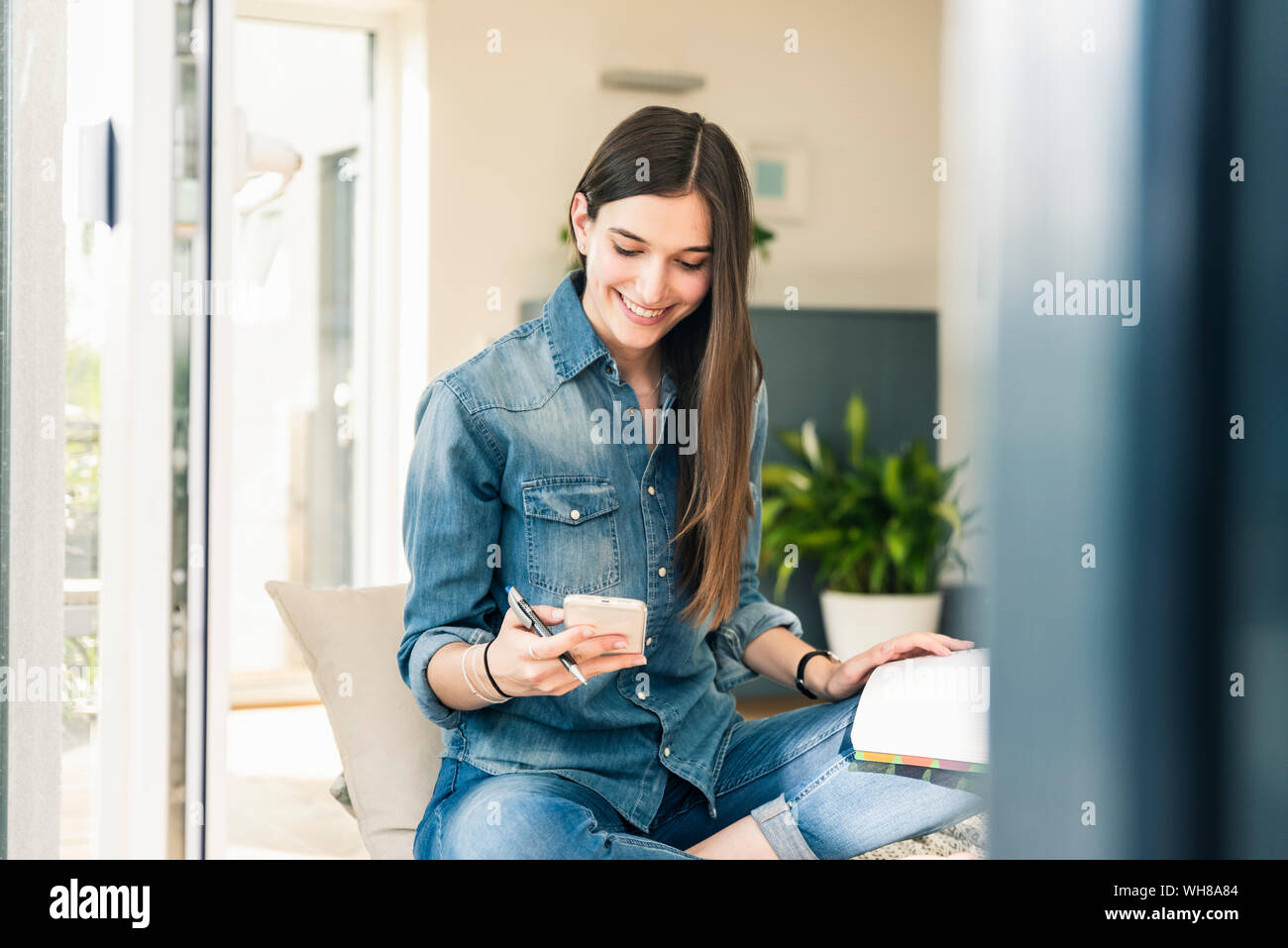 Smiling young woman checking hi-res stock photography and images - Alamy
