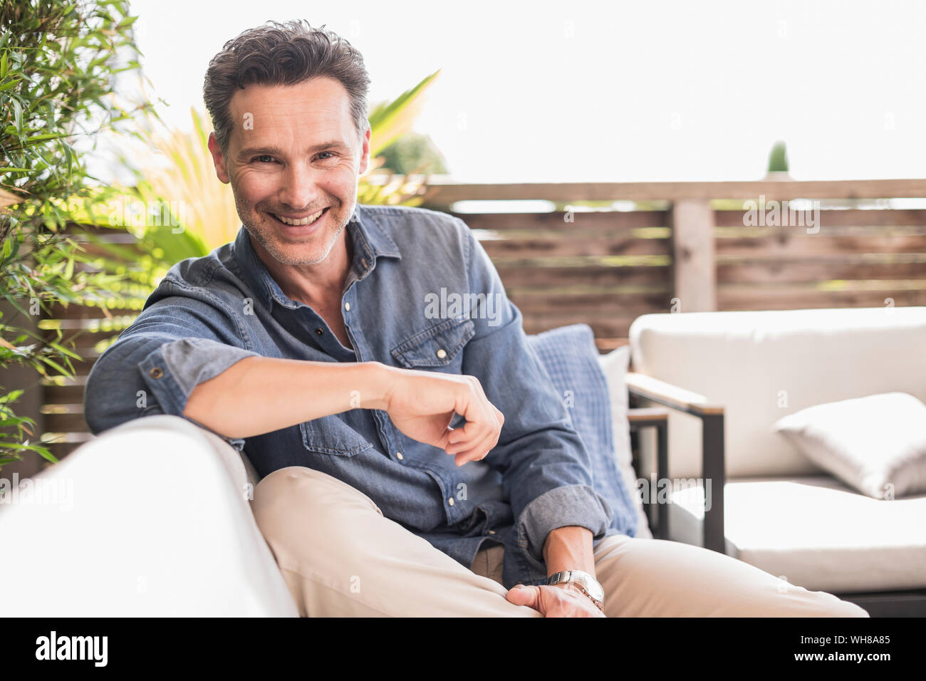 Confident man relaxing on the terrace Stock Photo - Alamy