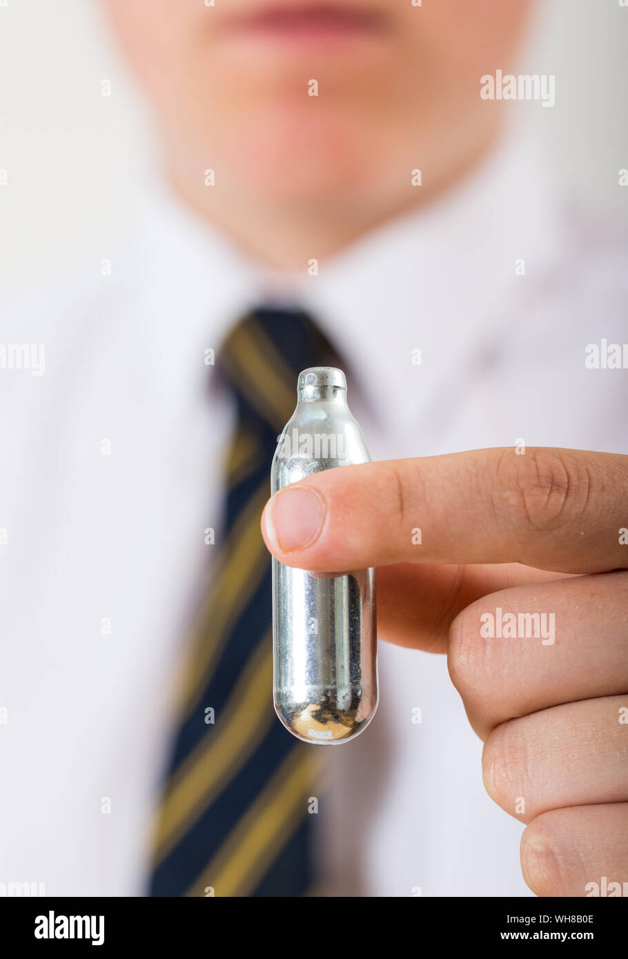 A school pupil holding a Nitrous oxide (laughing gas) canister Stock ...