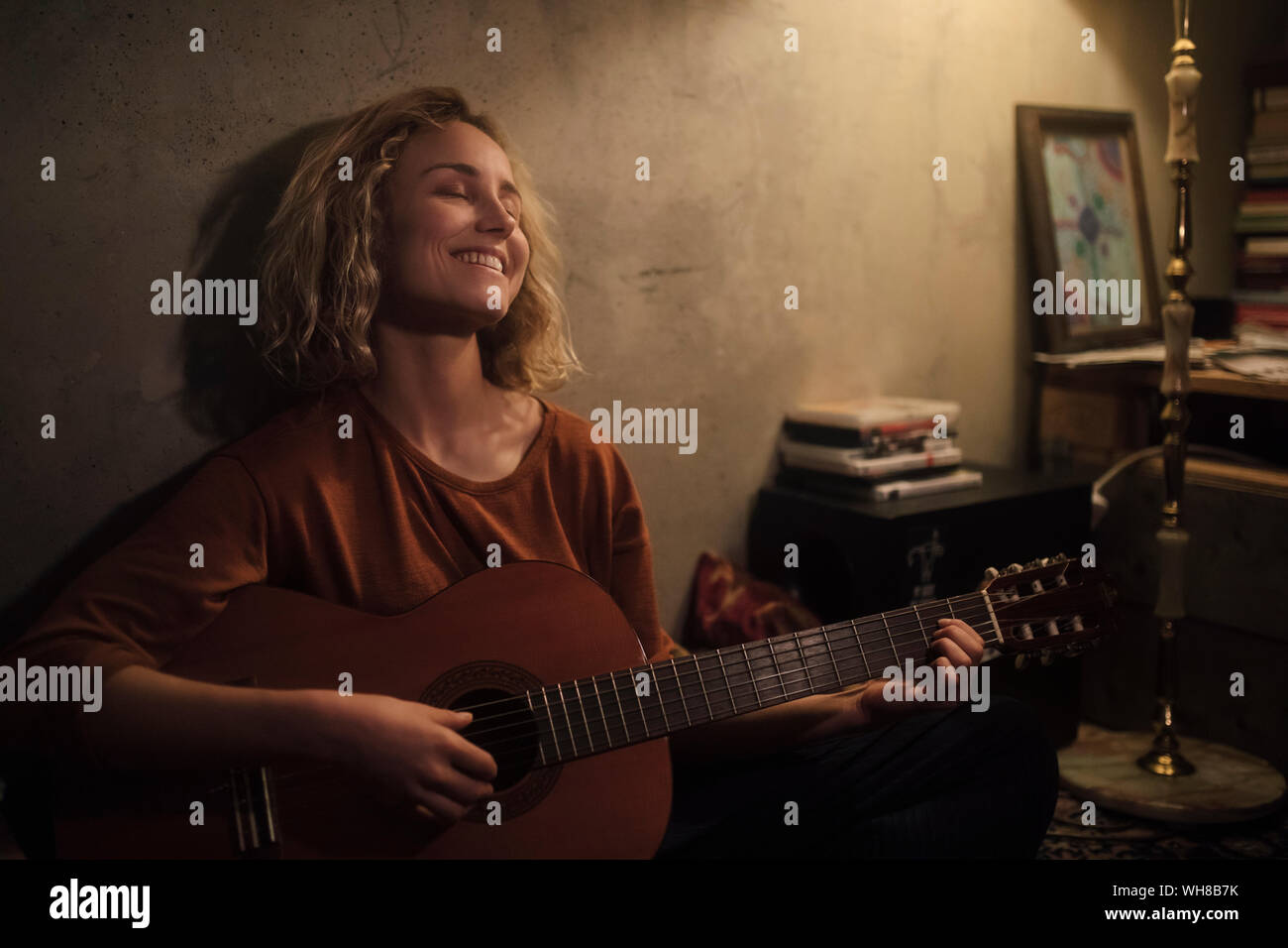 Beautiful woman playing guitar home hi-res stock photography and images ...