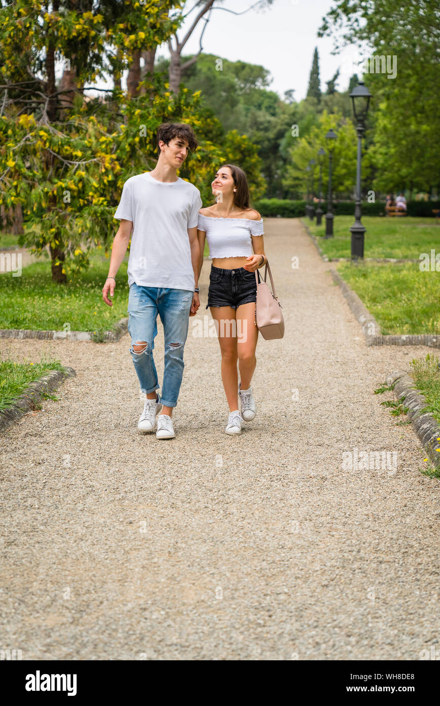 Young couple walking together in a park Stock Photo - Alamy