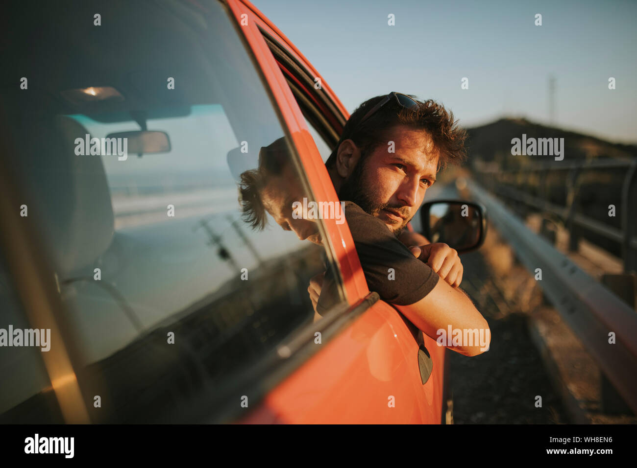 Man on a road trip looking out of car window Stock Photo - Alamy