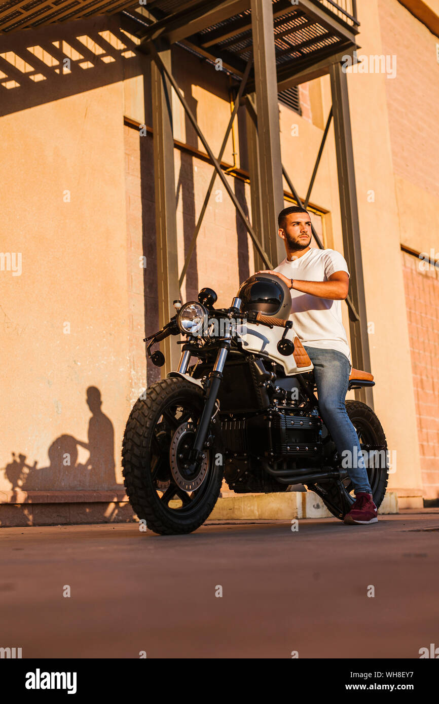 Portrait of young man sitting on his motorbike Stock Photo - Alamy