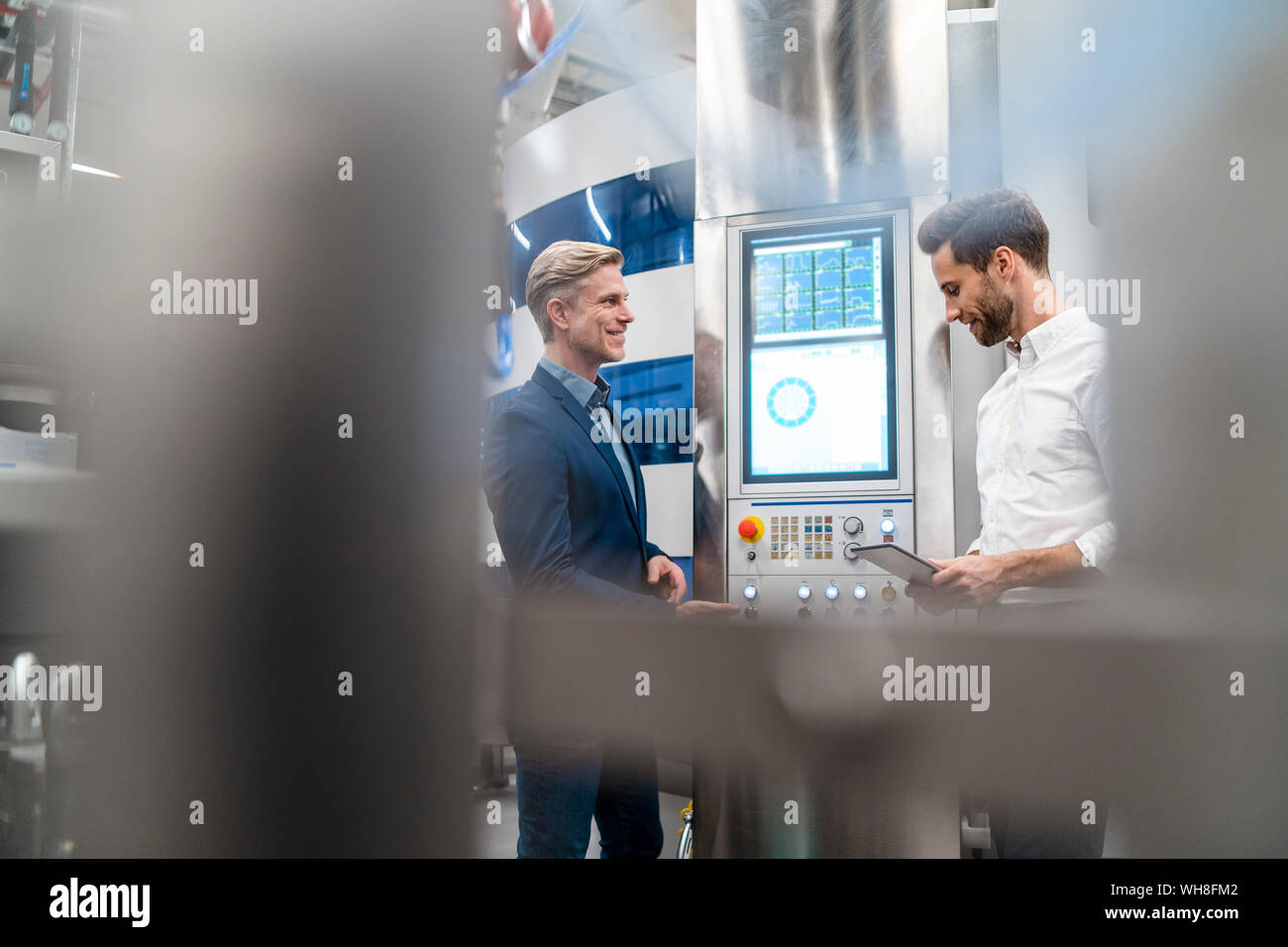 Two businessmen talking in a modern factory Stock Photo - Alamy