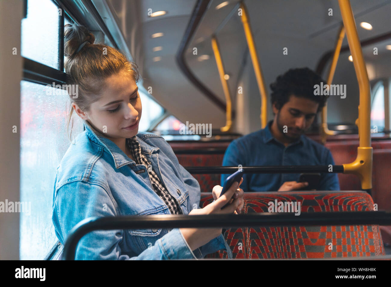 Man and woman using mobile phones in the bus Stock Photo - Alamy