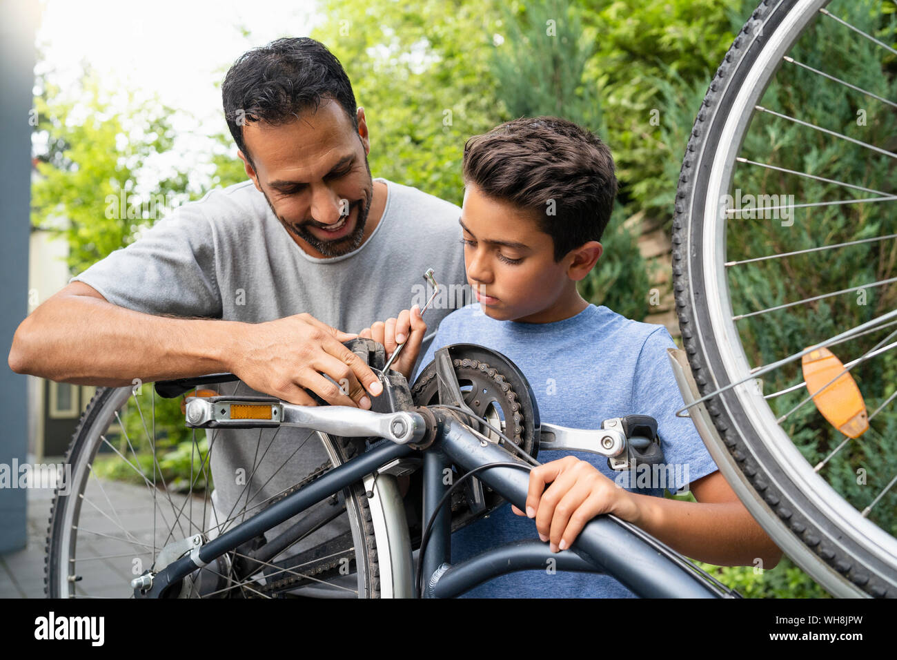 Son repairing bike hi-res stock photography and images - Alamy