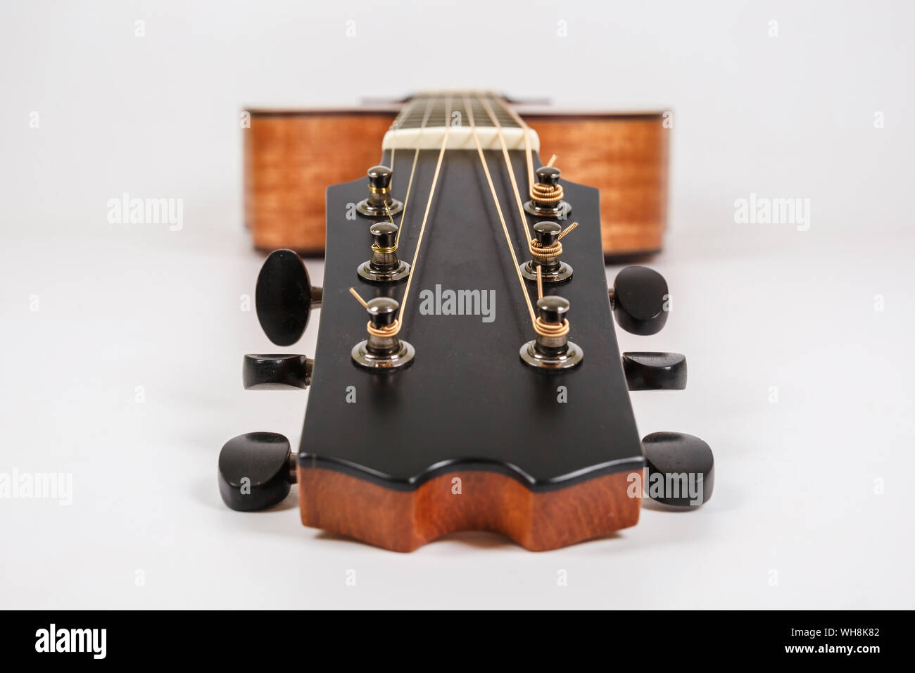 Tuning pegs on wooden machine head of six strings guitar on white ...