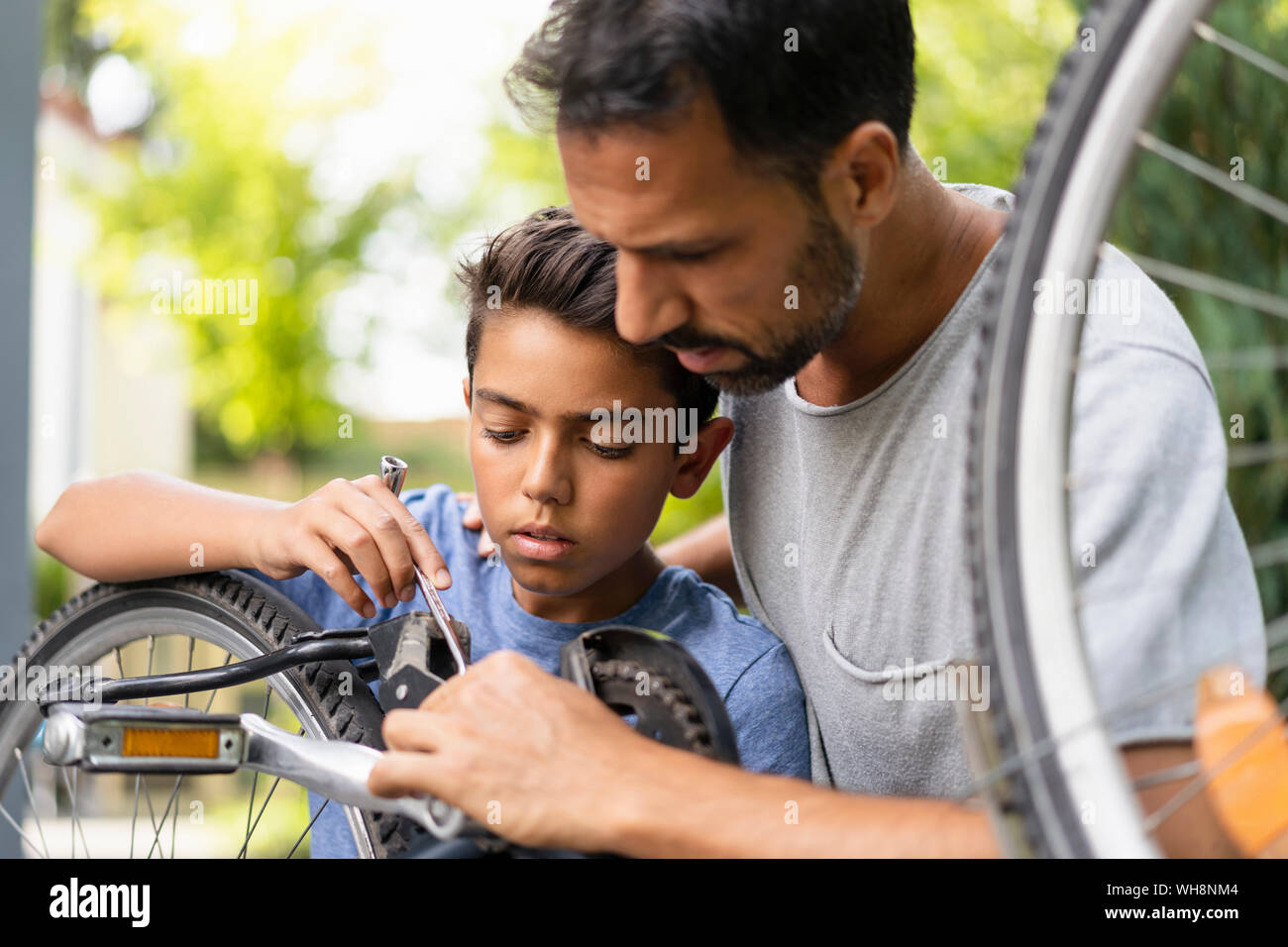 Father son repairing bicycle together home hi-res stock photography and ...