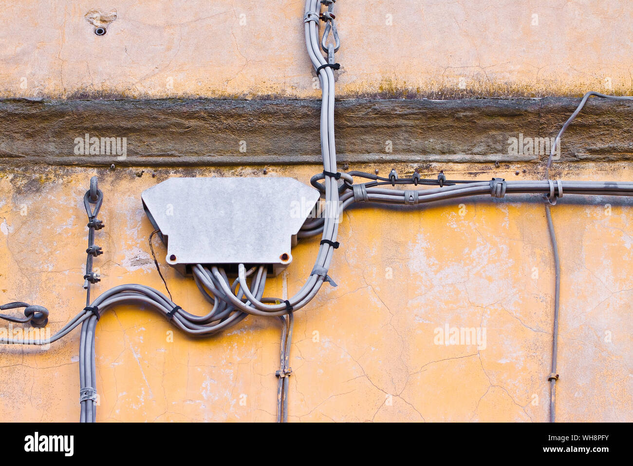 Electrical power and telephone cables fixwd to a plaster wall with ...