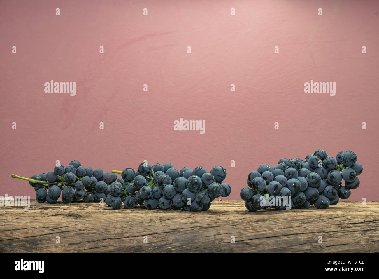 Beautiful wine Kadarka grapes on a old oak wooden table and red wall ...