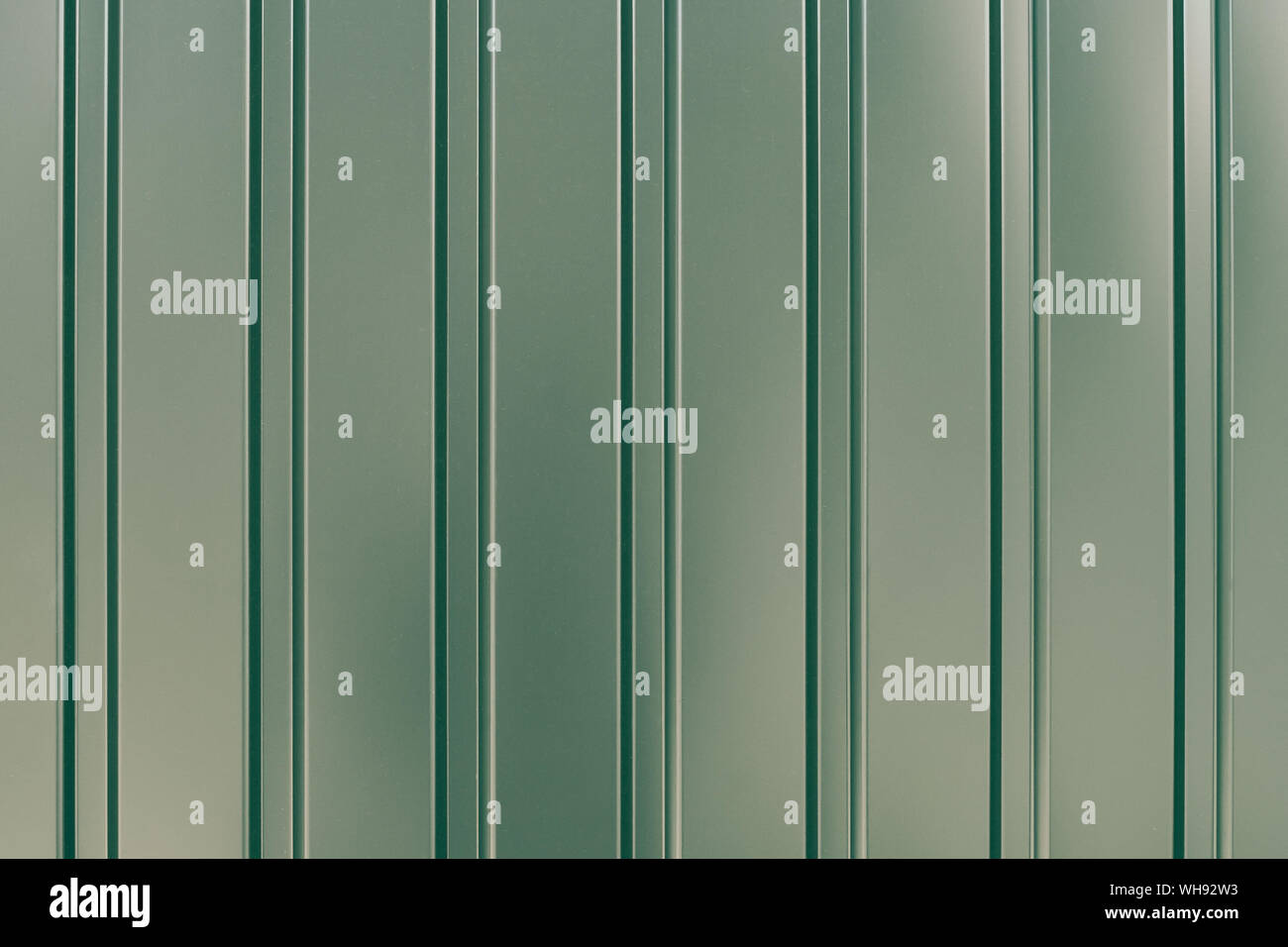 Green metallic striped surface. Metal wall siding. Striated fence with ...
