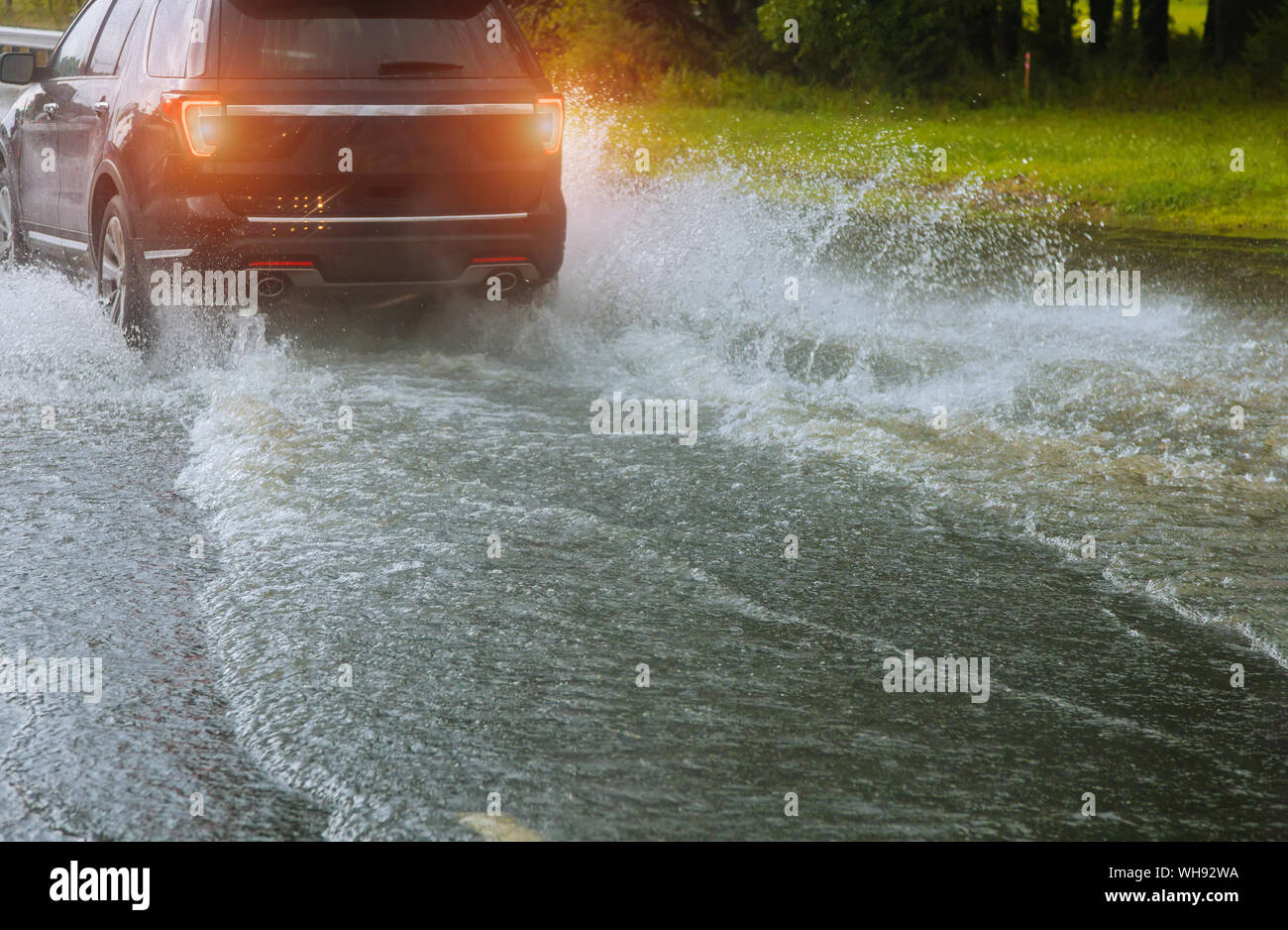 Cars float on water, flooding streets. spraying water of a car moving ...