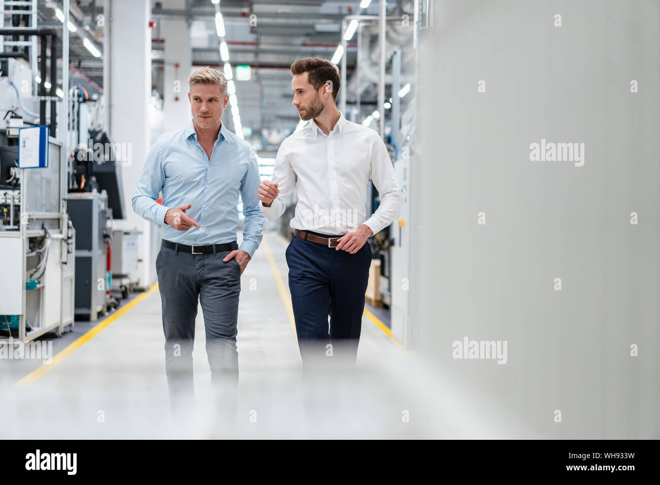 Two businessmen talking in a modern factory Stock Photo - Alamy