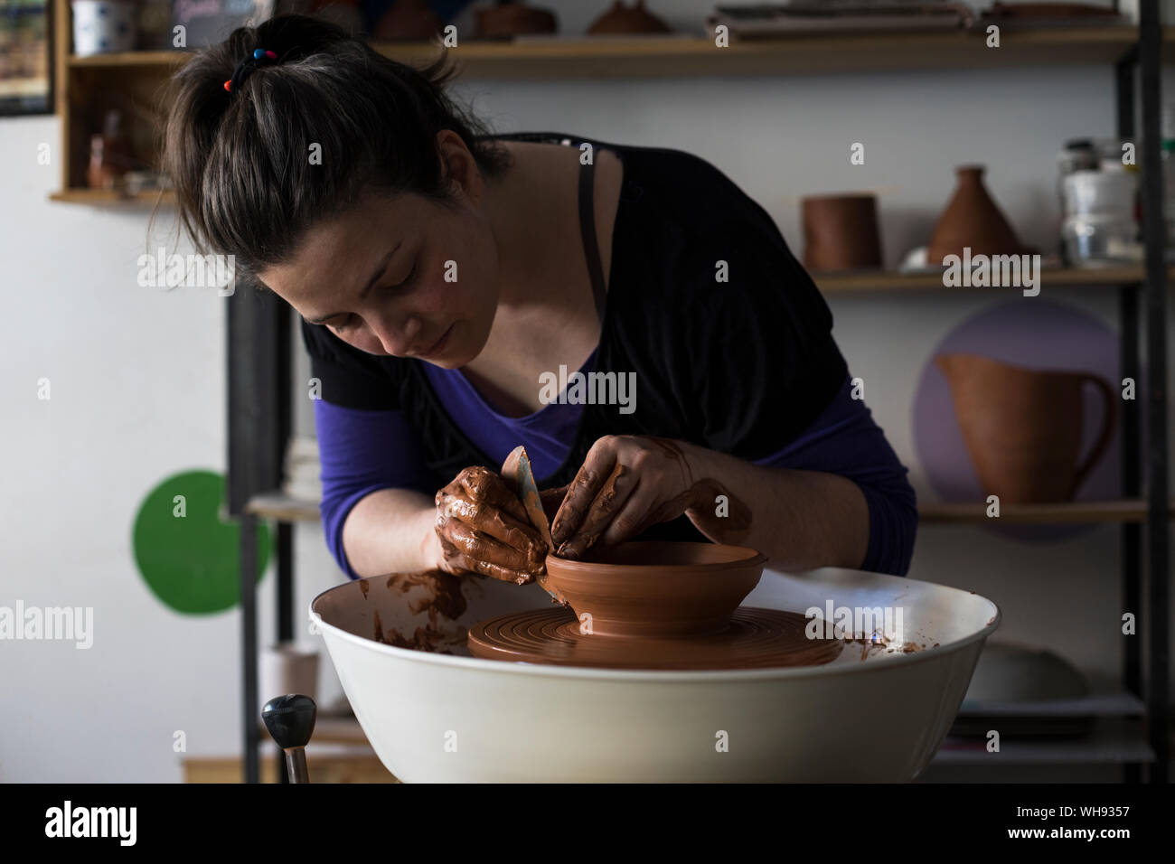 Potter forming clay on a wheel Stock Photo - Alamy