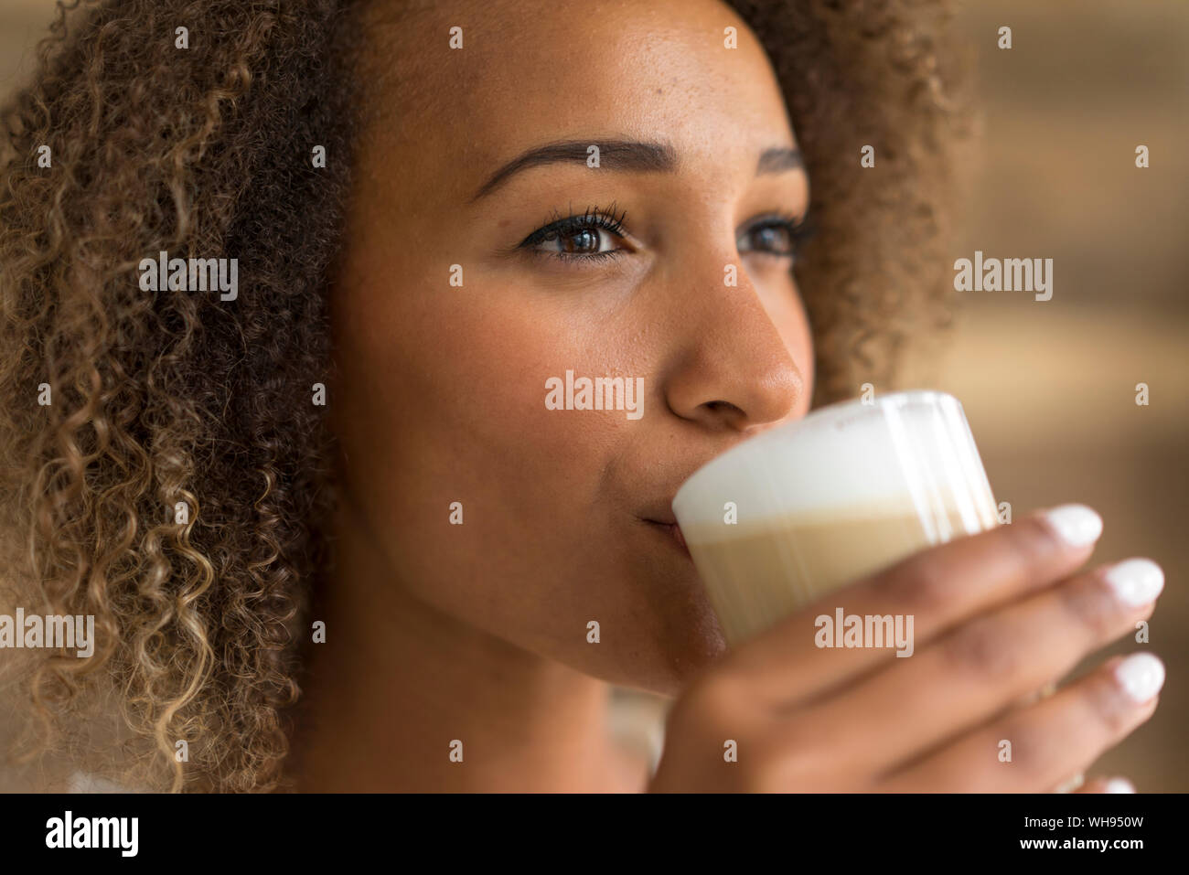 Young woman drinking Latte Macchiato Stock Photo - Alamy