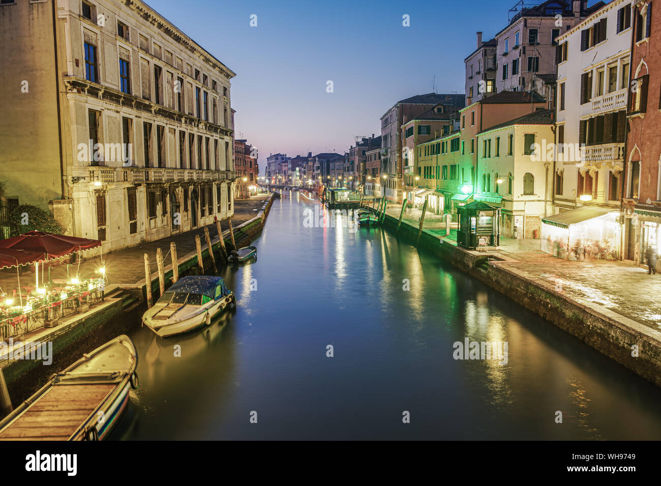 Evening canal view of low rise traditional buildings and wooden wharf ...