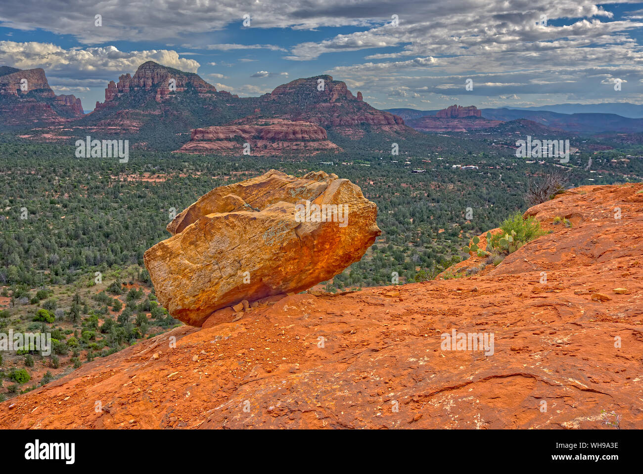 A boulder balanced on the edge of a cliff in Sedona with the Twin ...