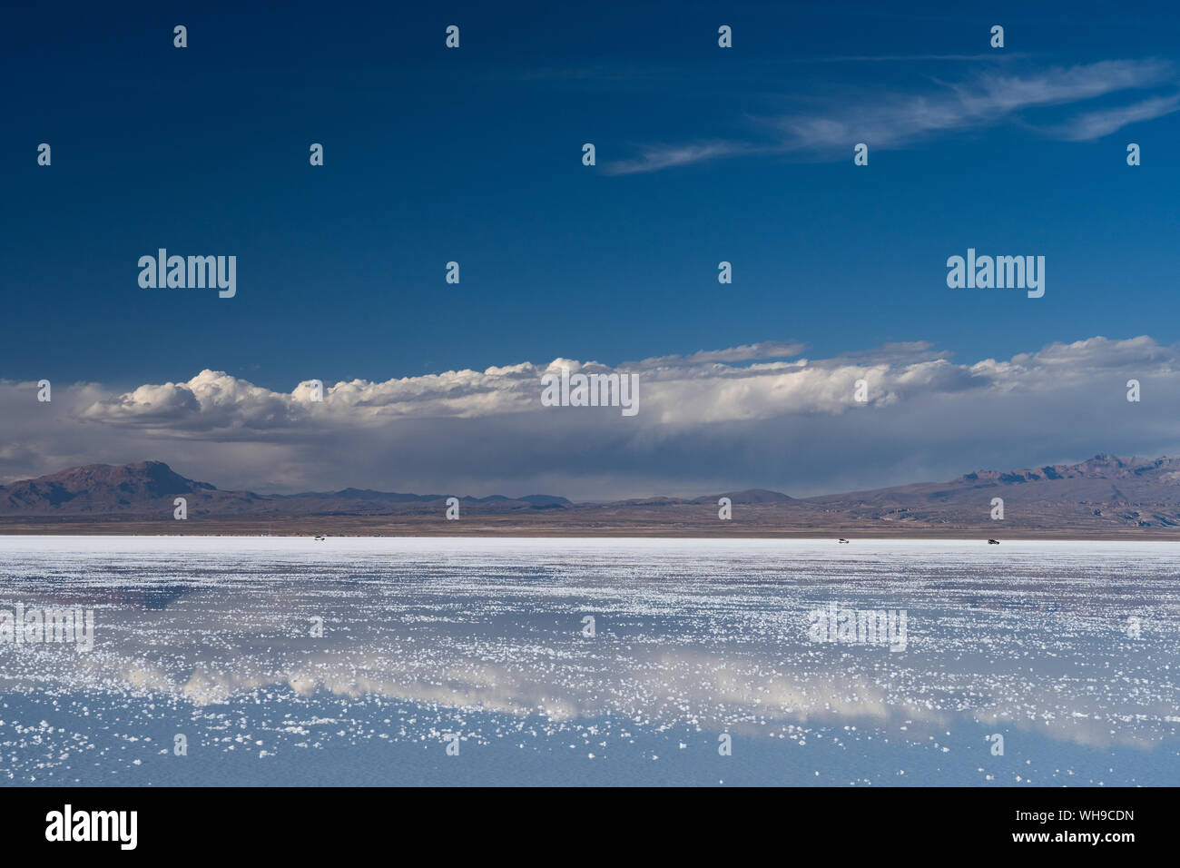 The beauty of the salt flats reflecting the clouds and mountains after ...
