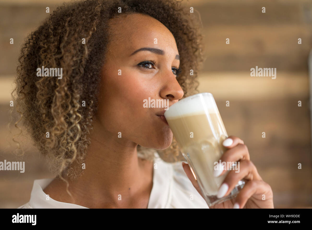 Young woman drinking Latte Macchiato Stock Photo - Alamy
