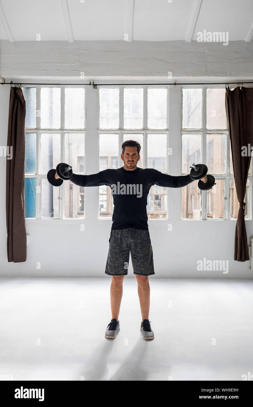 Mature man doing dumbell training in his loft Stock Photo - Alamy