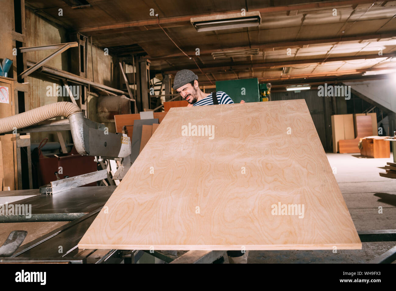 Carpenter checking wooden board Stock Photo - Alamy